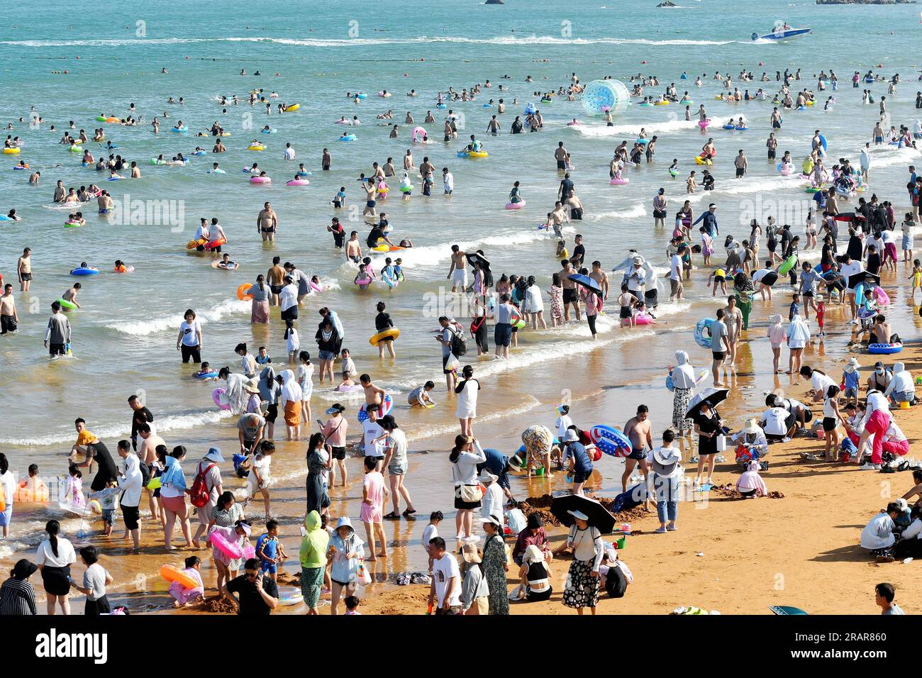QINGDAO, CHINA - JULY 5, 2023 - Tourists swim in the sea to escape the ...
