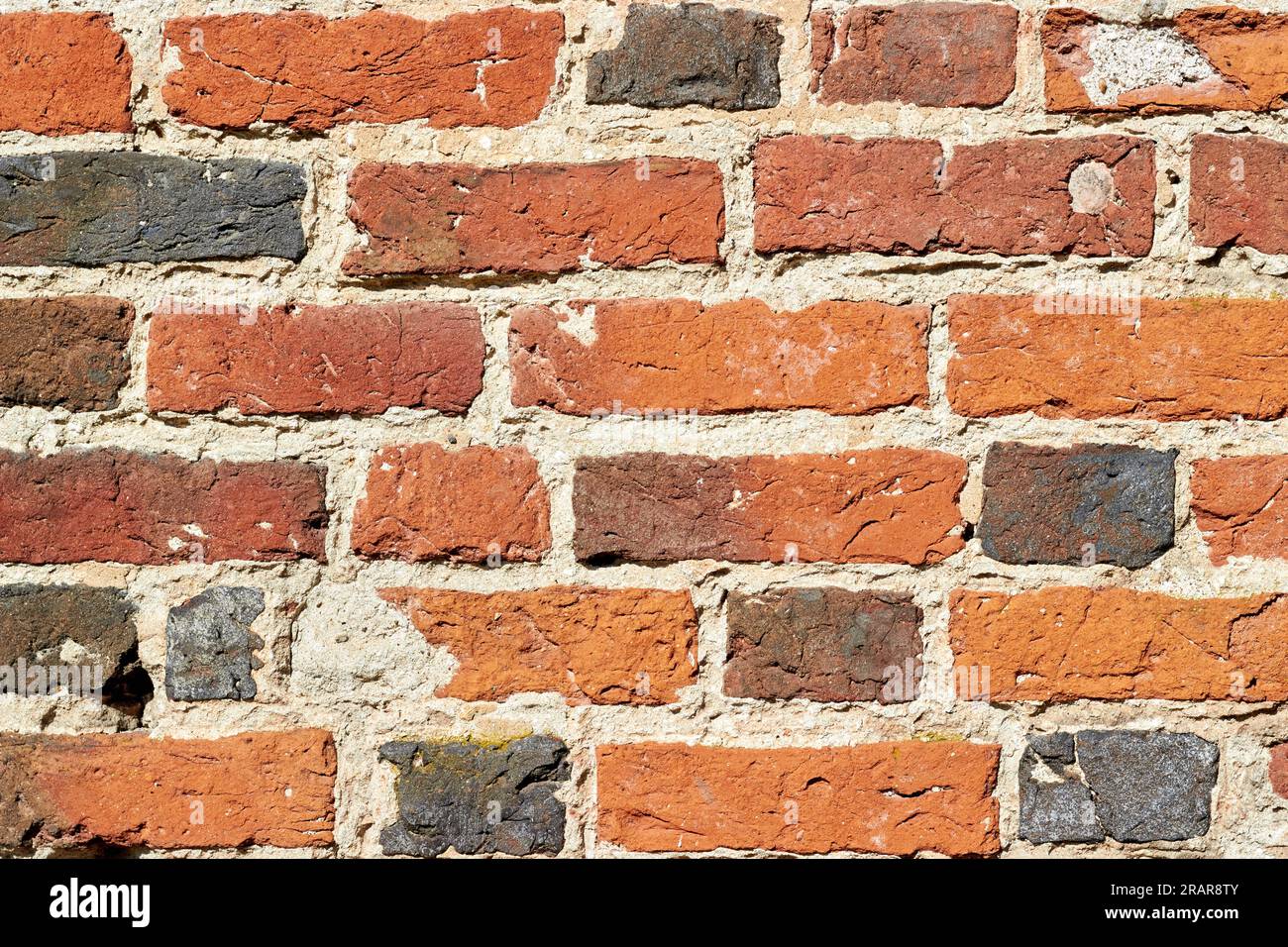 Wall of antique handmade baked bricks with cracks and holes. Background ...