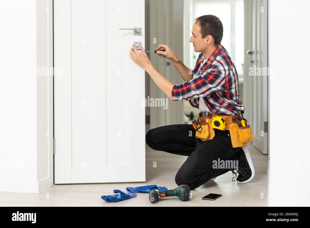 Installation of a lock on the front wooden entrance door. Portrait of ...