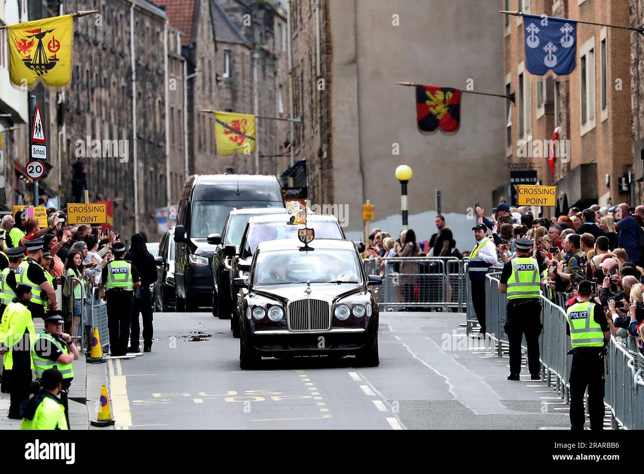 The motorcade of Britain's King Charles III drives along the Royal Mile ...