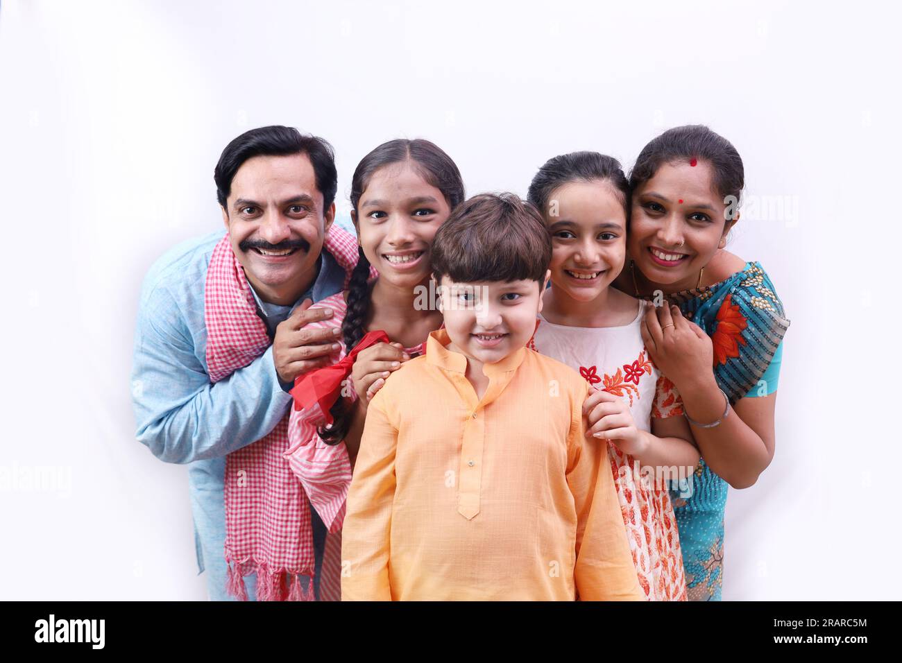 Indian rural happy villager family standing together on a white ...
