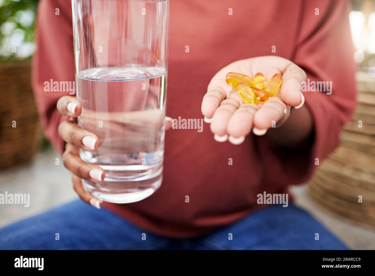 Hand of woman, water and supplement pills for health, diet and commitment to nutrition or ...