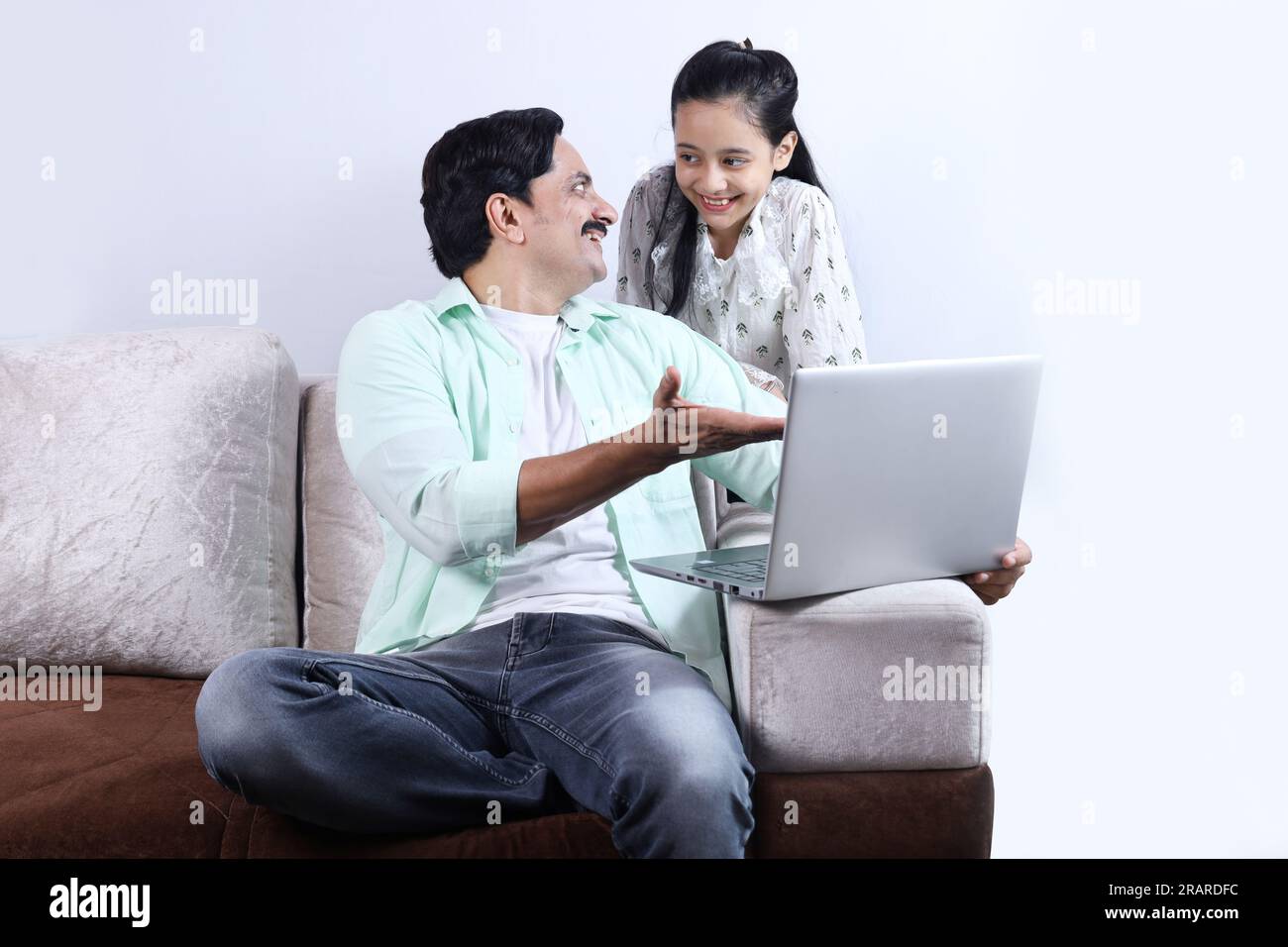 Happy Indian family of single father and daughter surfing laptop having ...