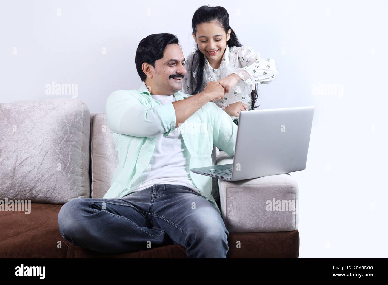Happy Indian family of single father and daughter surfing laptop having ...
