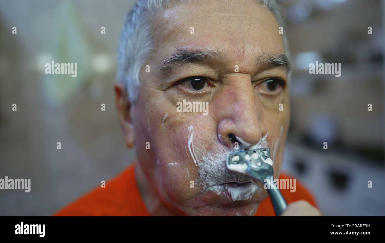 Older man shaving beard in front of bathroom mirror, old age domestic ...