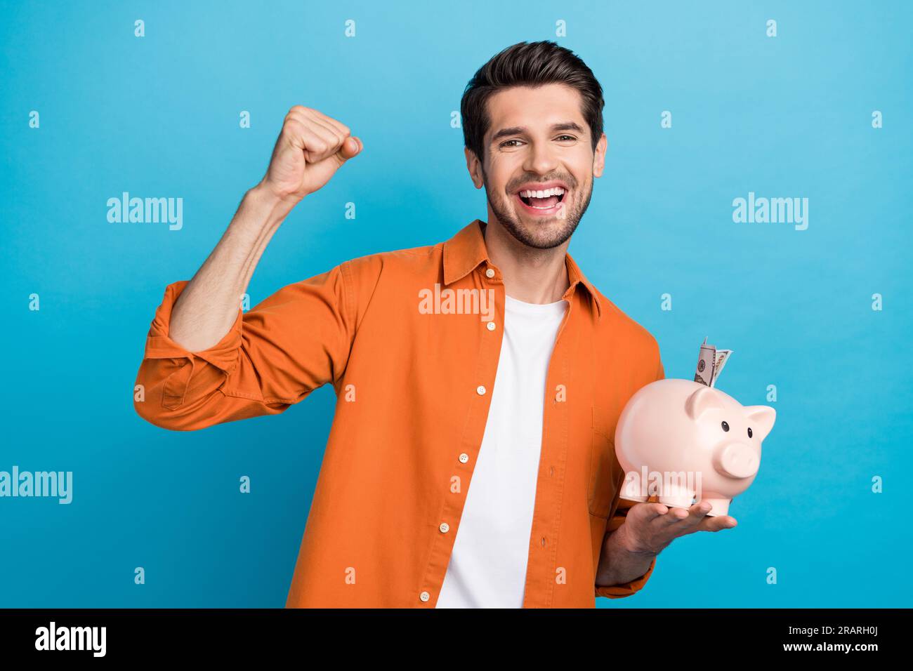 Photo of crazy delighted person raise fist hand hold money bank pig ...