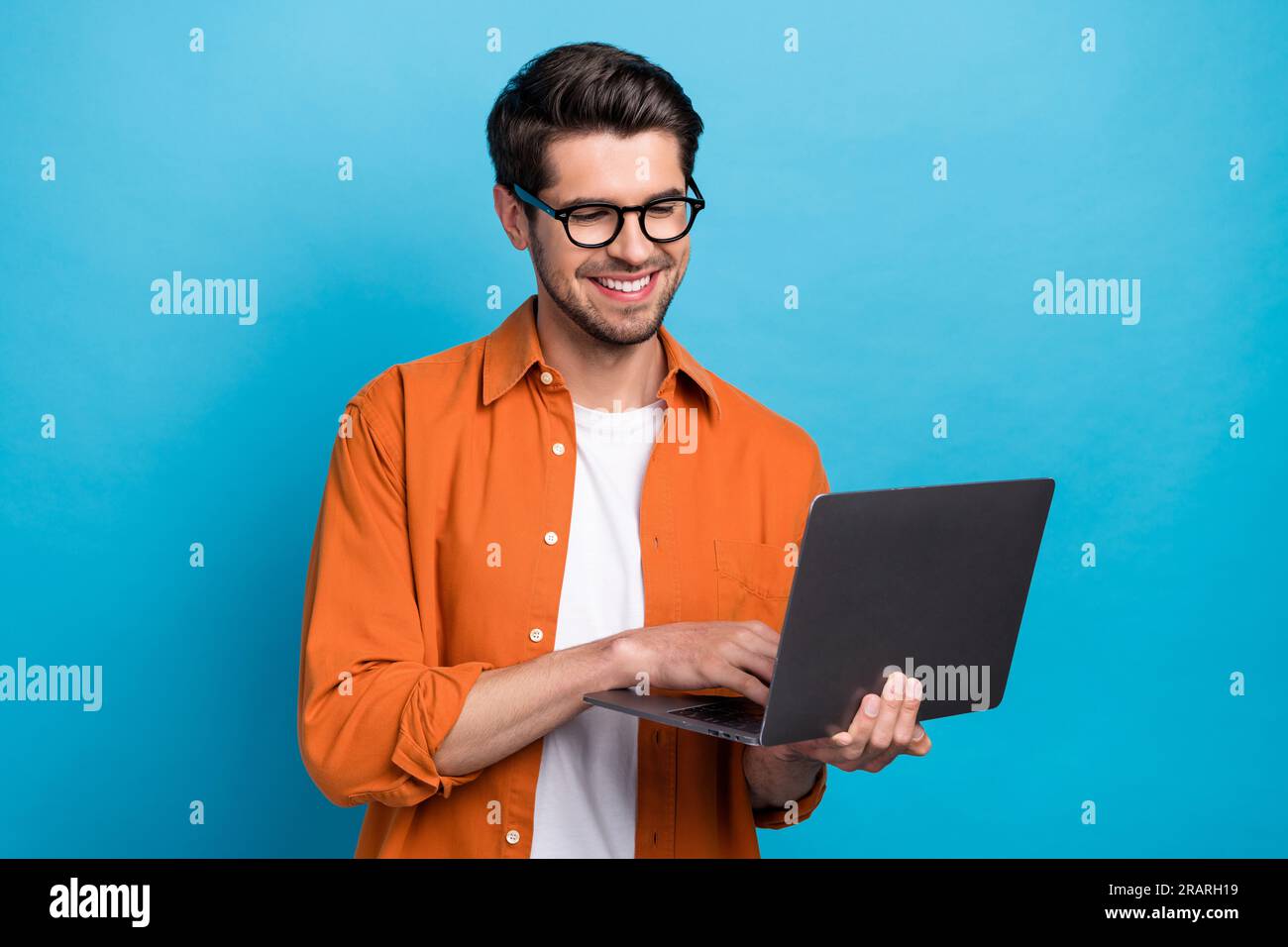 Portrait of handsome positive person beaming smile use wireless netbook ...