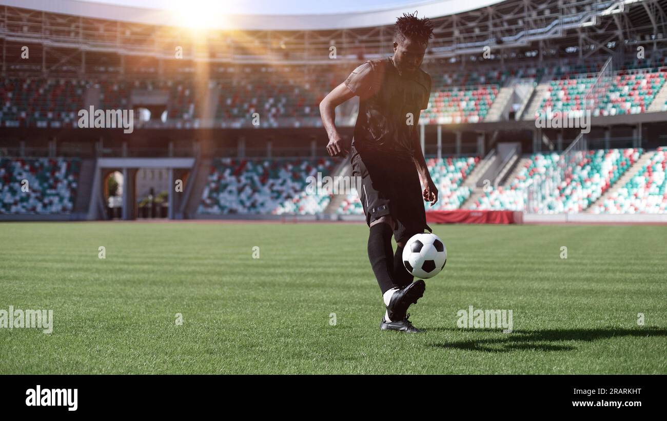 African American man playing football on the stadium field. A man runs ...