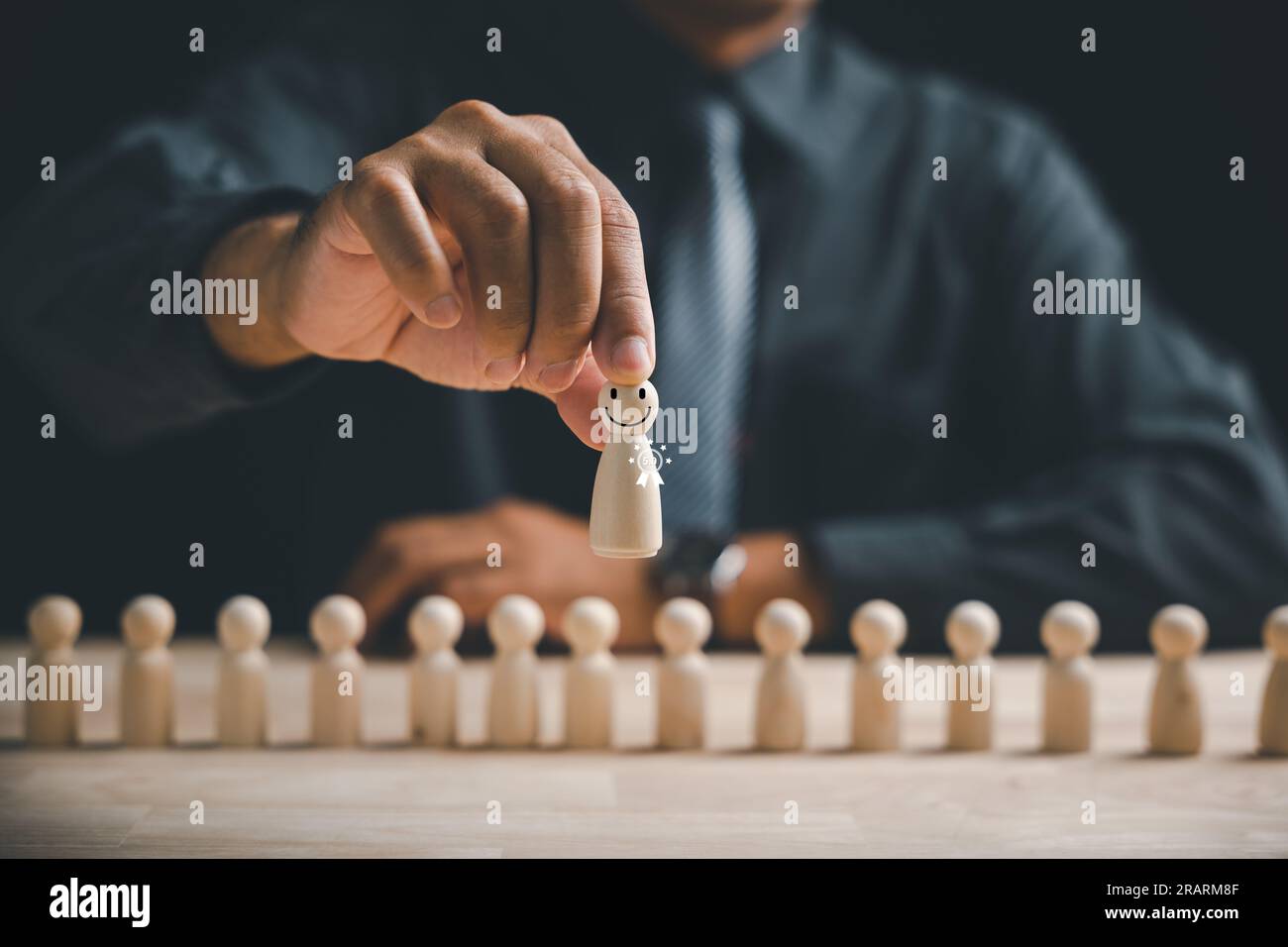 Hand choosing a wooden figure as the chosen leader from the crowd Stock ...