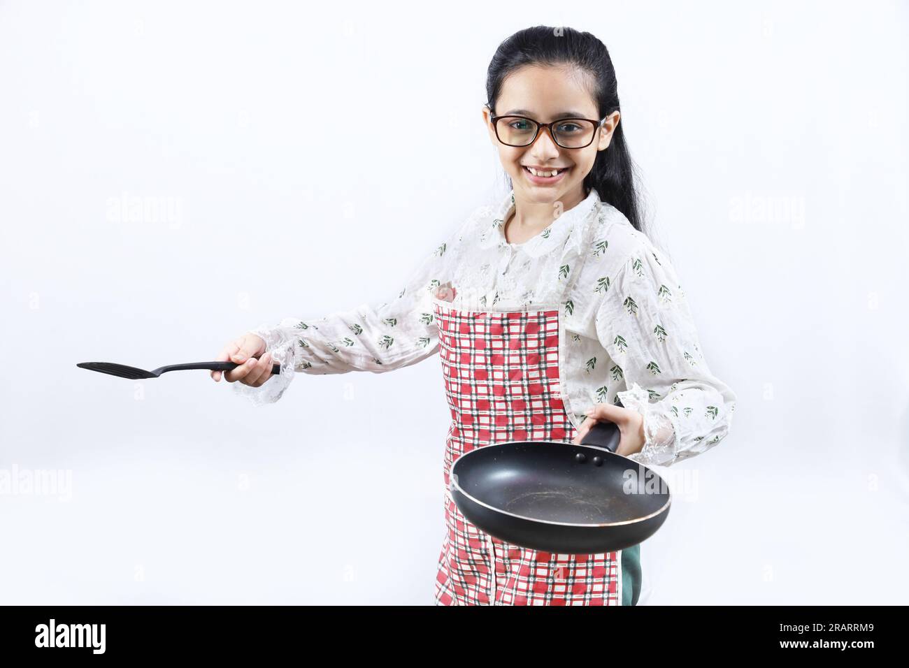 Portrait of Happy Indian teenage girl in kitchen holding cooking ...
