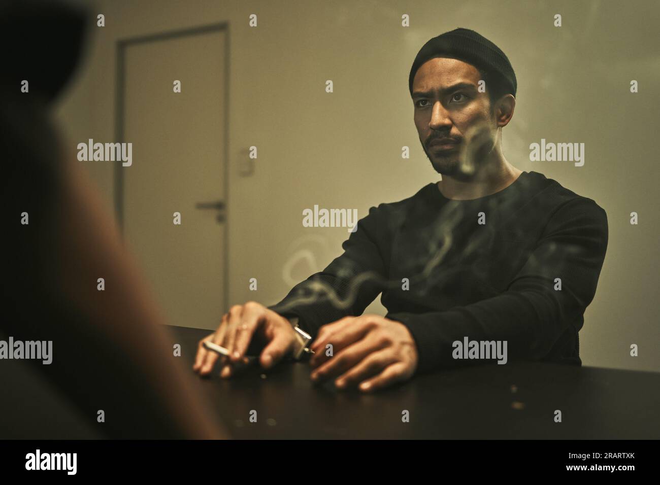 Man in investigation, smoking and detective in interrogation room with ...