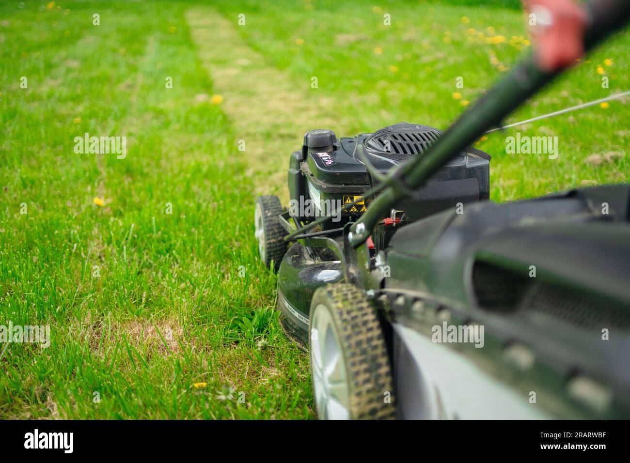 Lawn mover on green grass in modern garden. Machine for cutting lawns ...