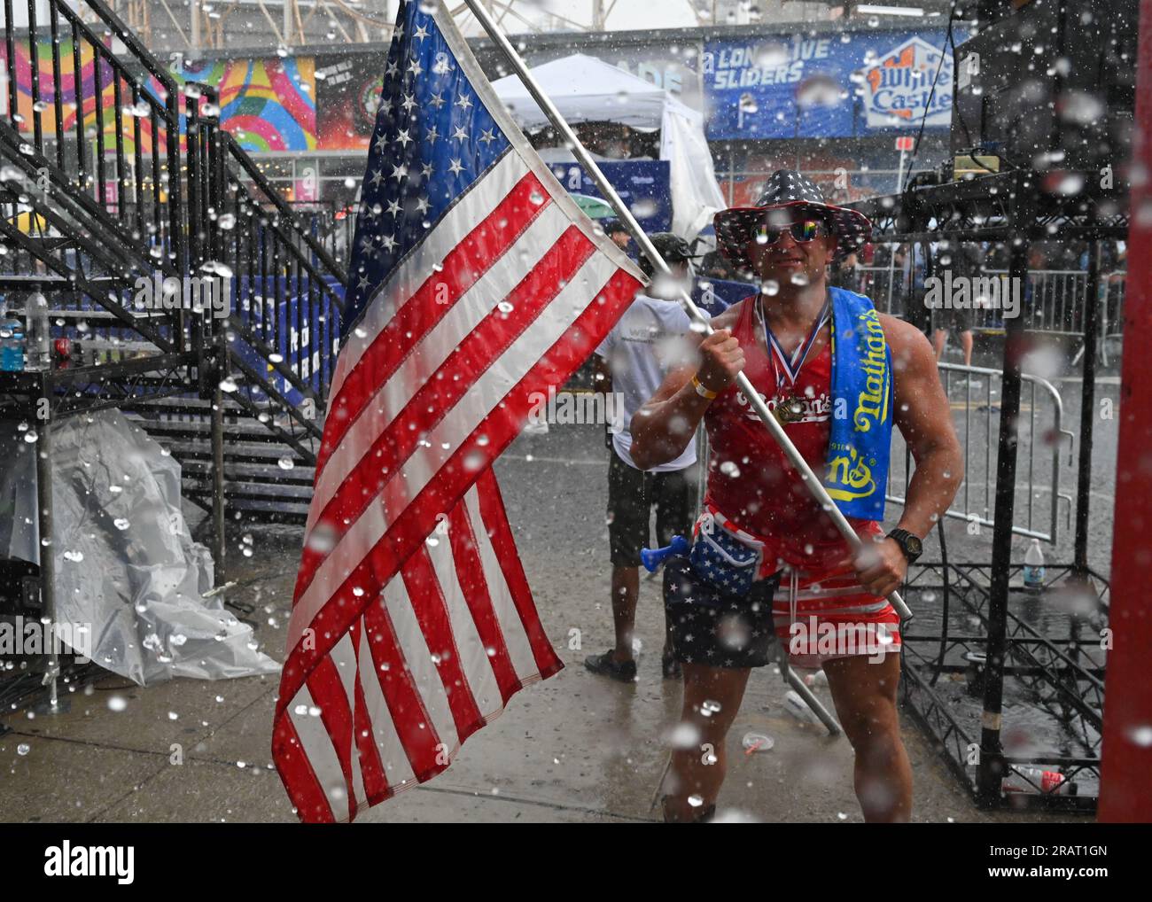 People stand in the rain at the Nathan's Famous International Hot Dog ...