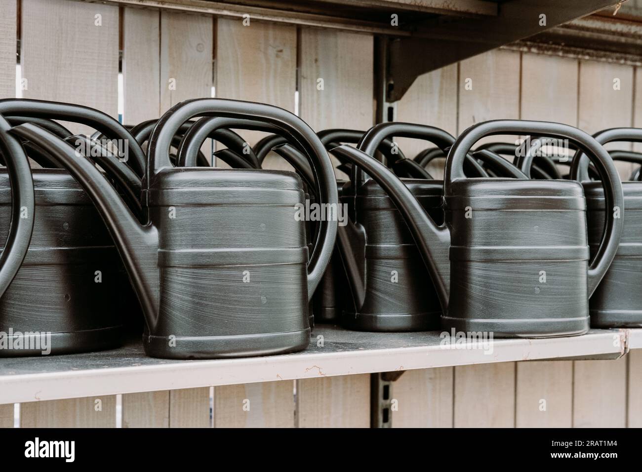 Black plastic watering cans for sale at the garden center Stock Photo ...