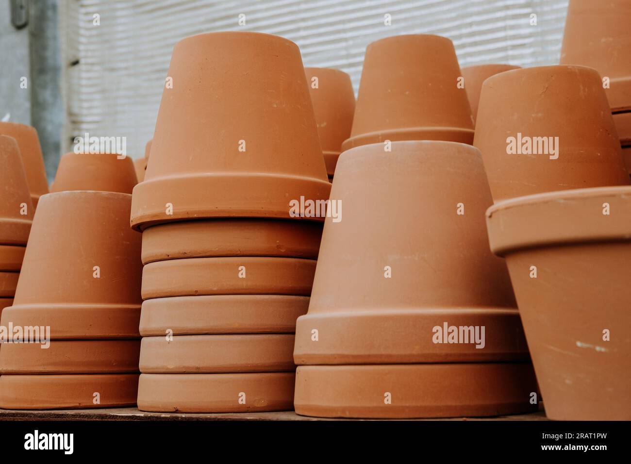 Stacked terra cotta flower pots on the shelves at the garden center ...