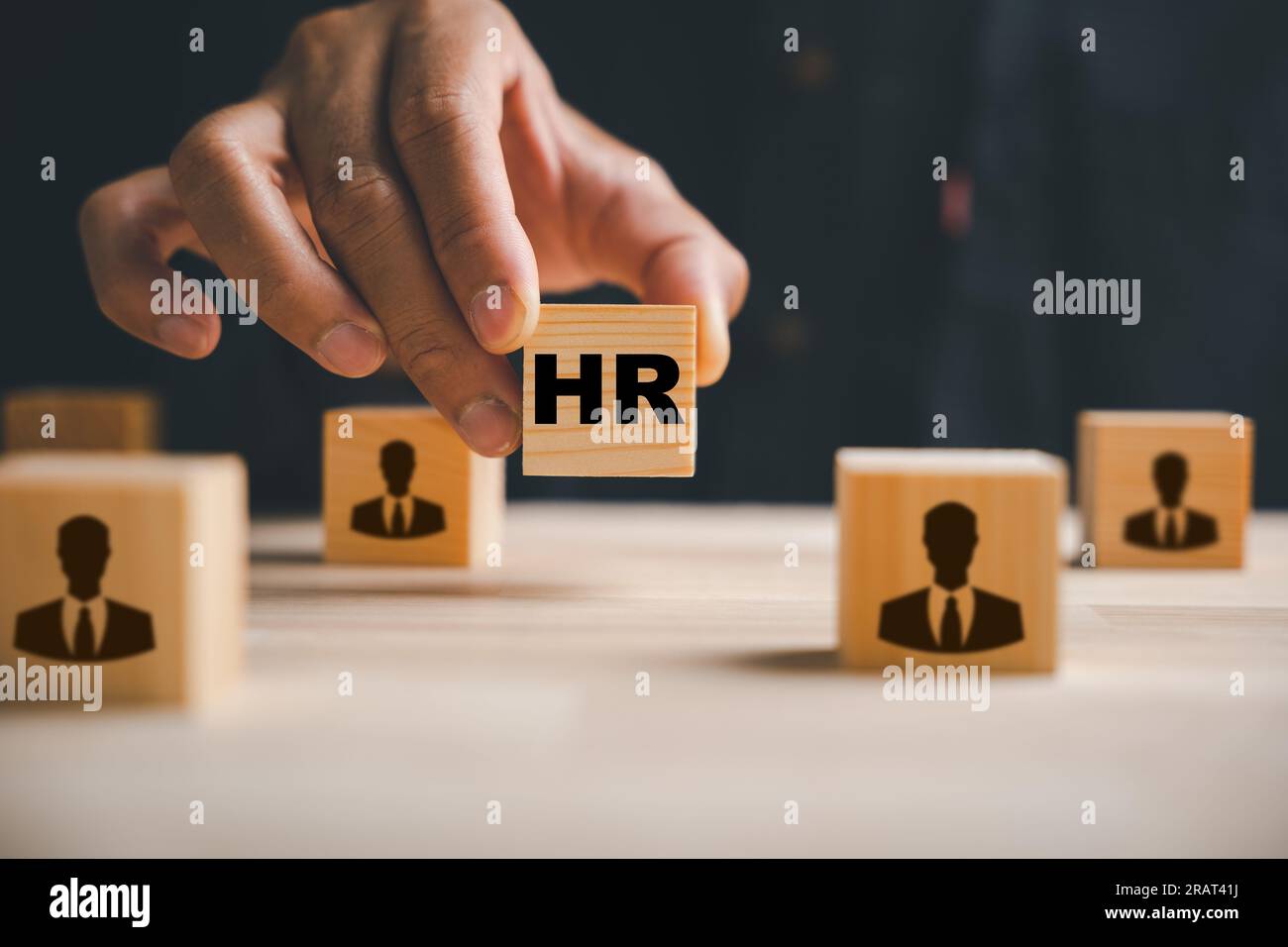 Hand reaching for red human icon on wooden block Stock Photo - Alamy
