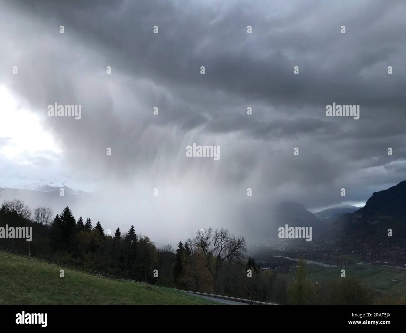 mountain scenery on a cloudy day where you can see the rain fall and ...