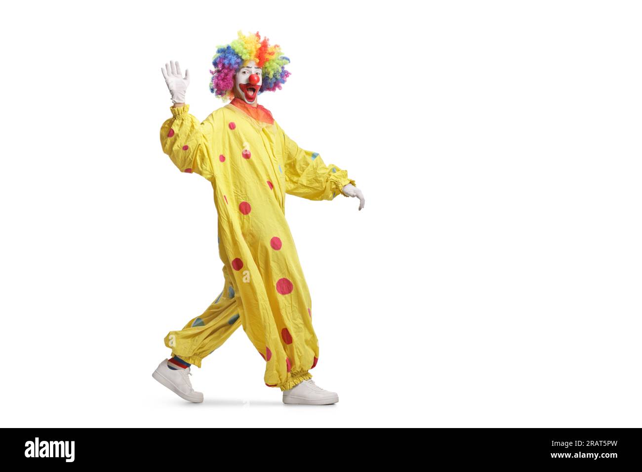 Full length shot of a clown in yellow costume walking and waving ...