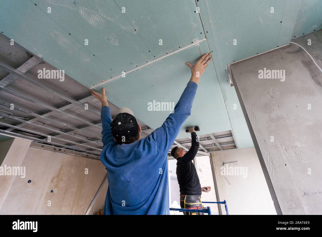 Workers fitting panel into frame of ceiling Stock Photo - Alamy