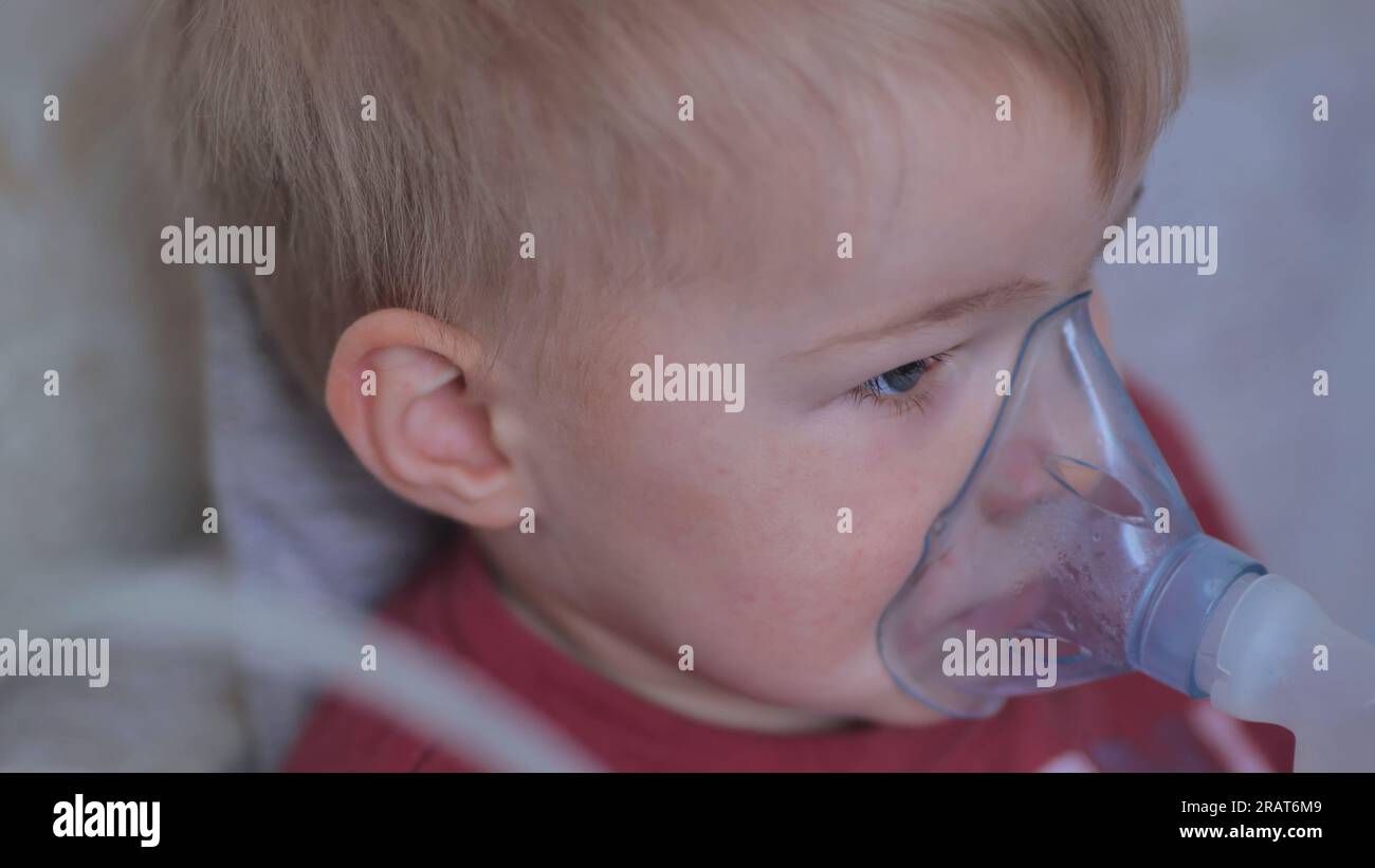 Funny boy breathing through an inhaler mask Stock Photo - Alamy