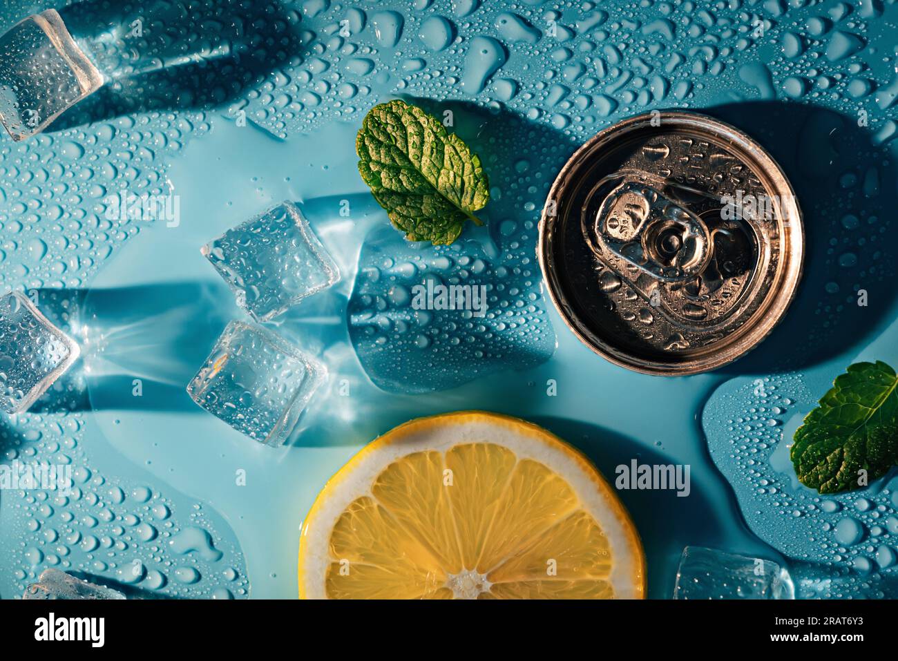 Creative summer composition with lemon slice, mint leaves, can of soda and ice cubes. Top down ...