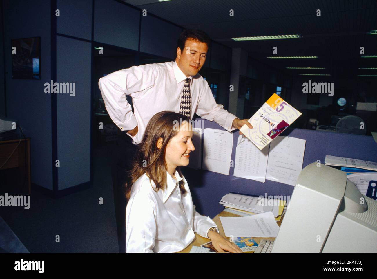 Open Plan Office Secretary Using Computer with Boss overlooking Holiday ...