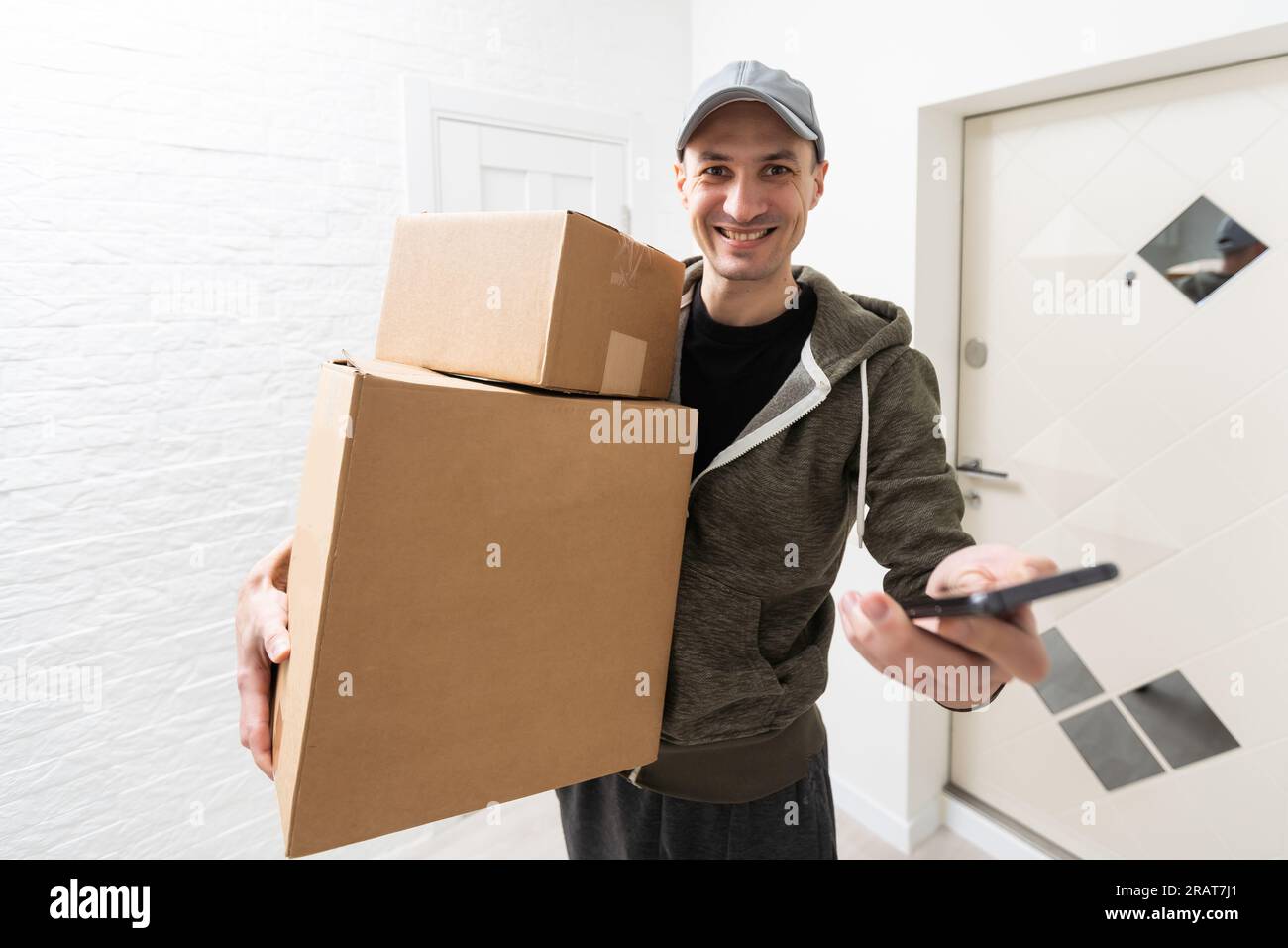 Full length portrait of smiling delivery man with package and clipboard ...