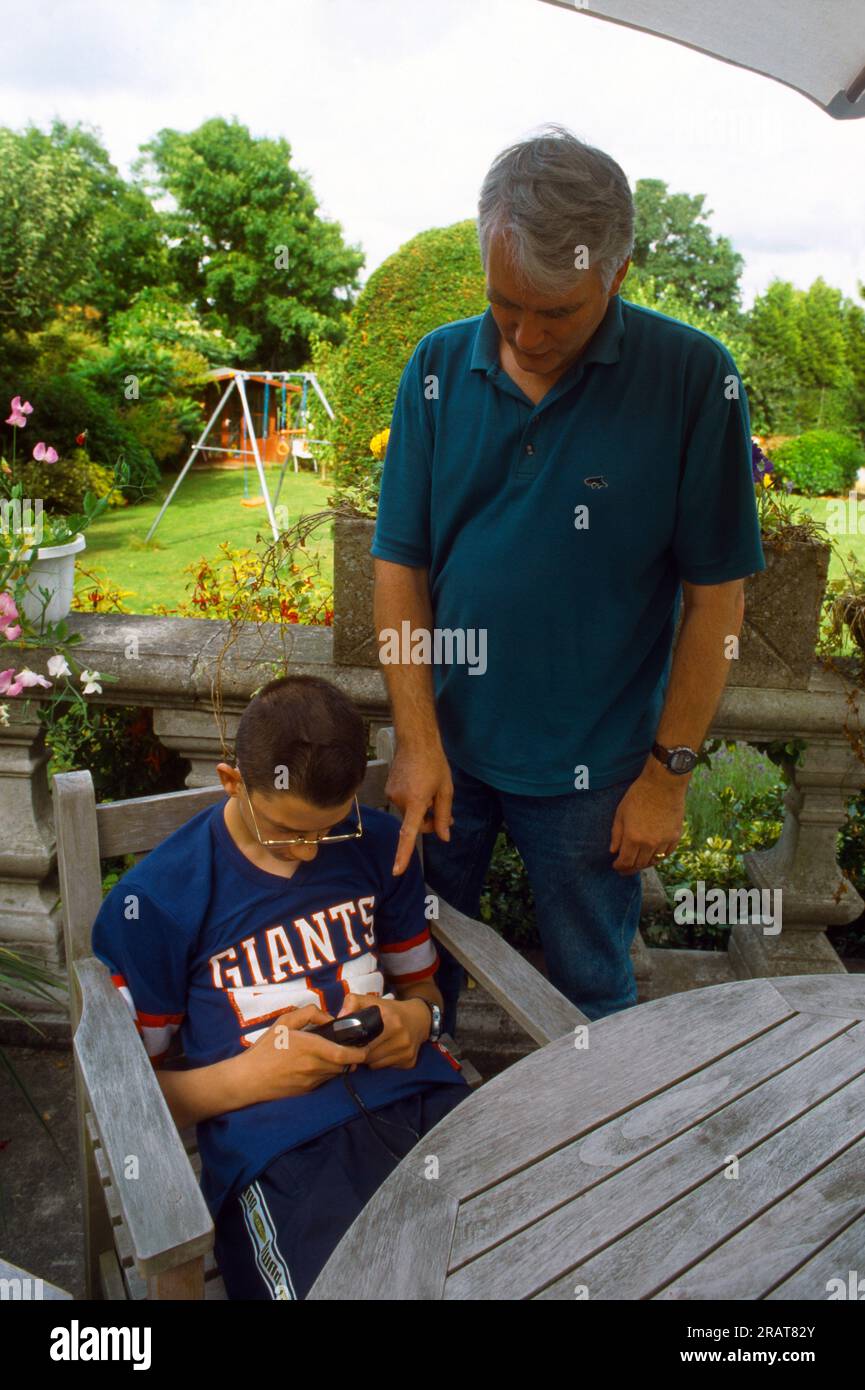 Fourteen Year Old Boy Using Mobile Phone while Ignoring His Father ...