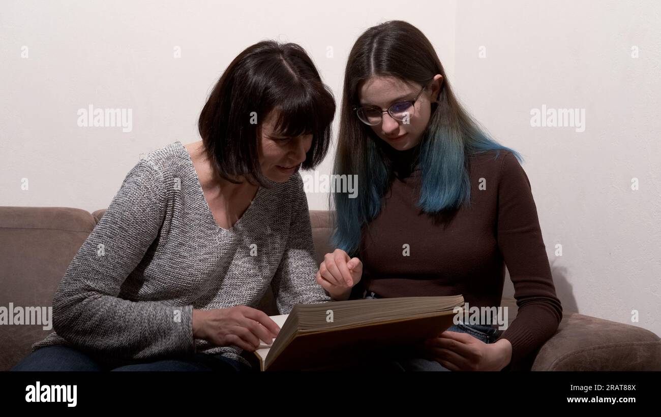 Mother and daughter watch family photos, remember pleasant moments ...