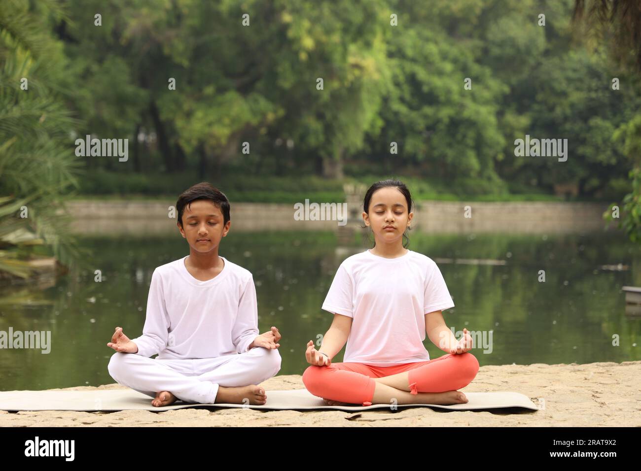 Children exercising and doing Yoga poses in green serene environment ...