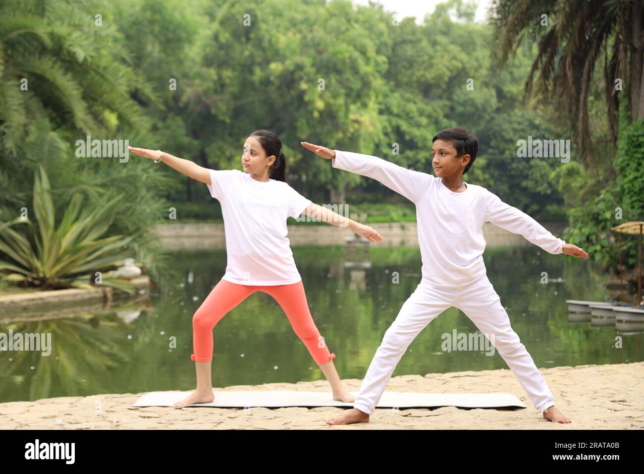 Children exercising and doing Yoga poses in green serene environment ...