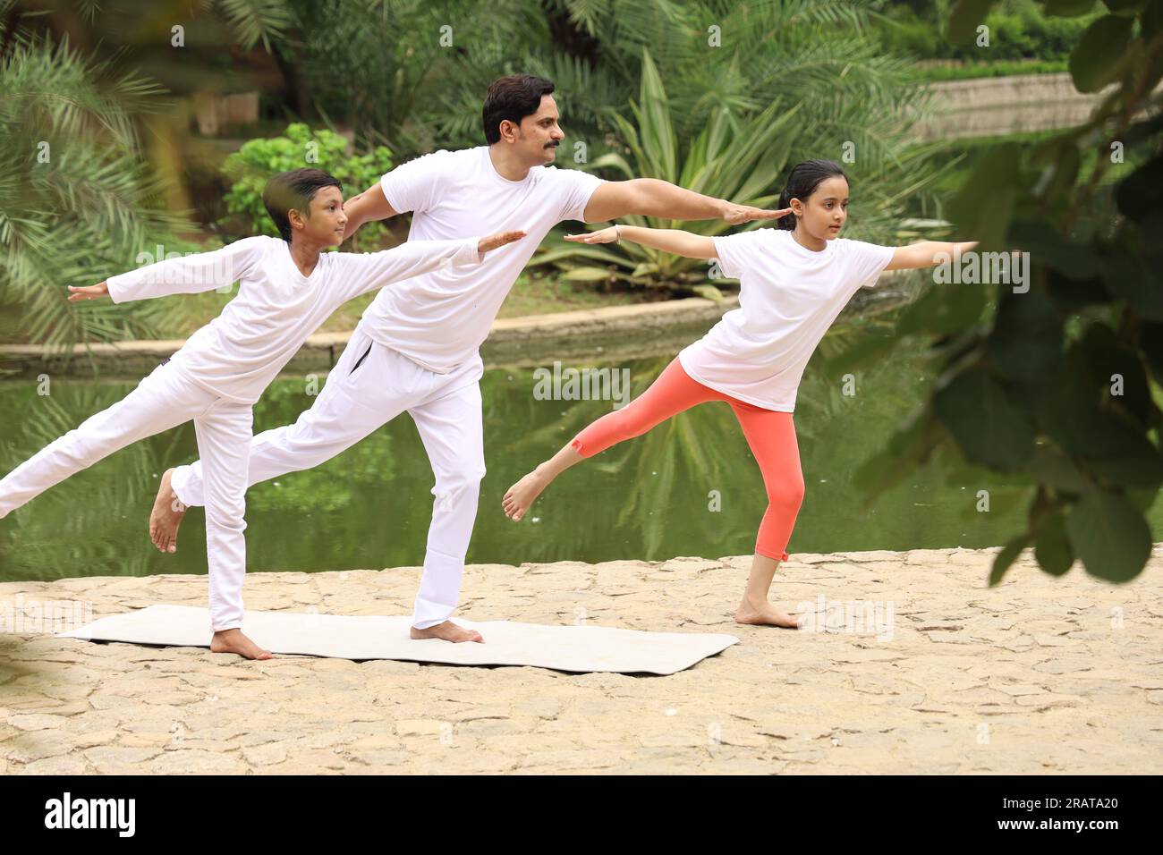 Trainer exercising and teaching kids the yoga poses in green ...