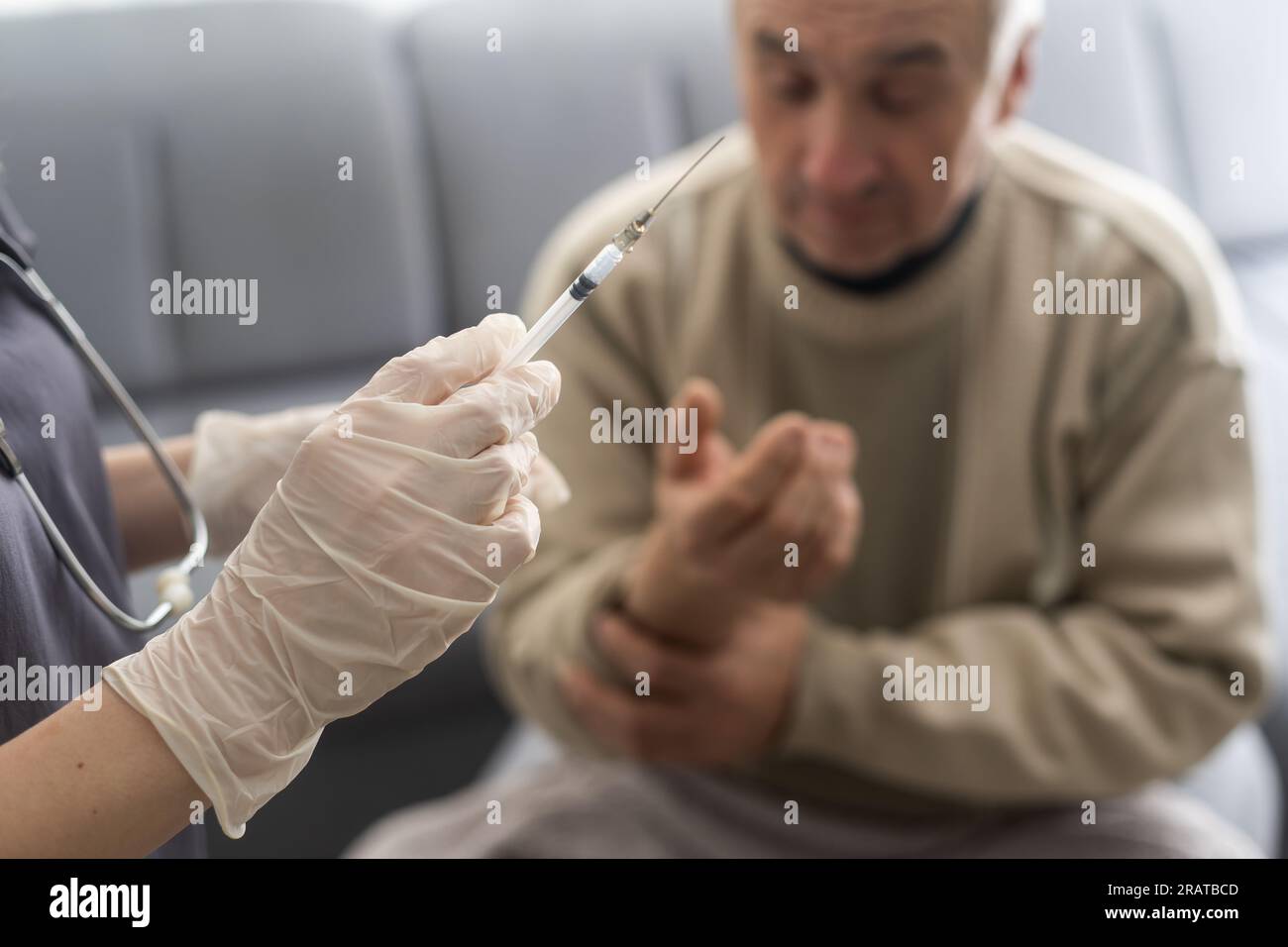 Doctor giving vaccination shot to elderly patient by syringe or ...