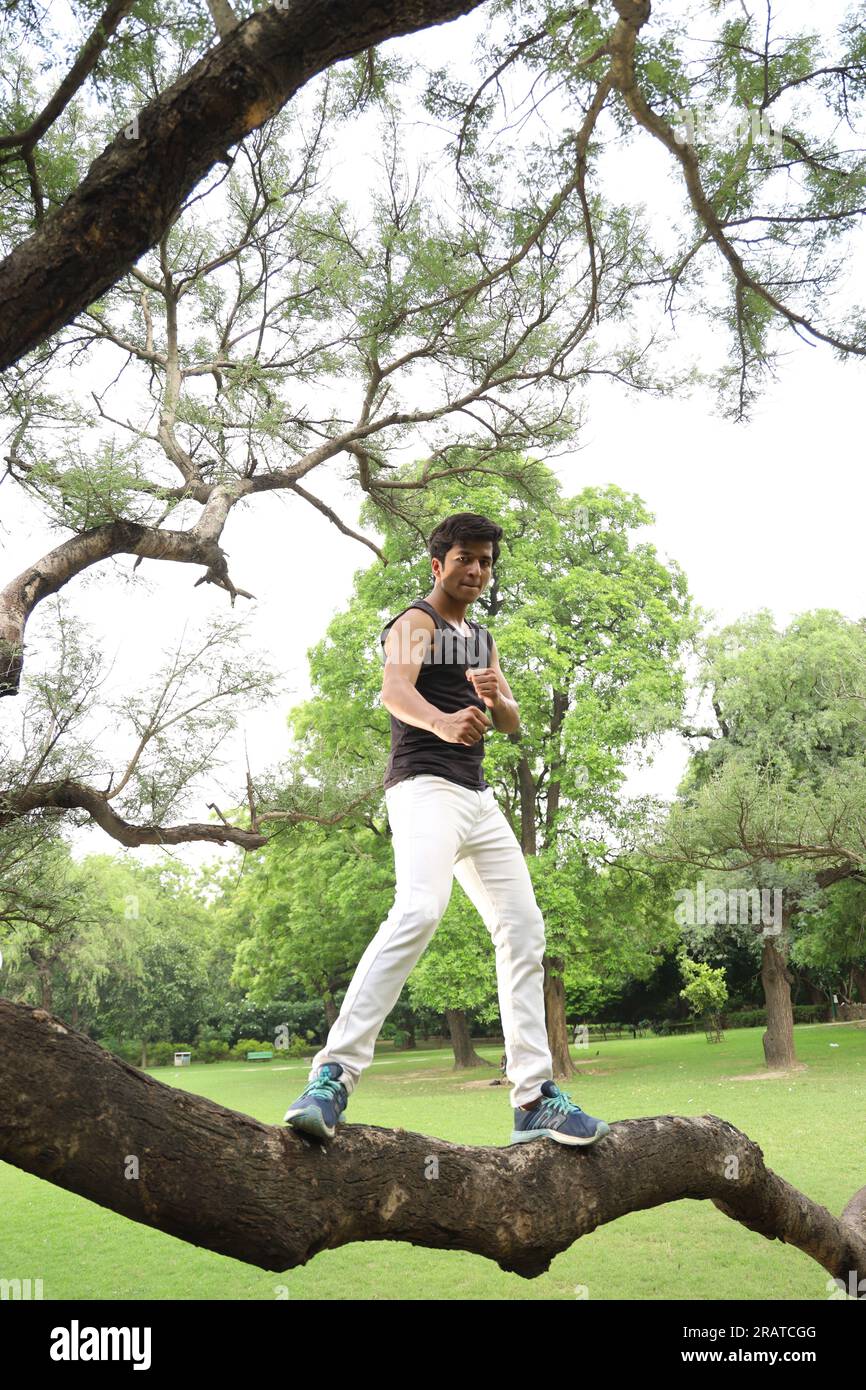 Young teen boy posing in the park in greens and serene atmosphere ...