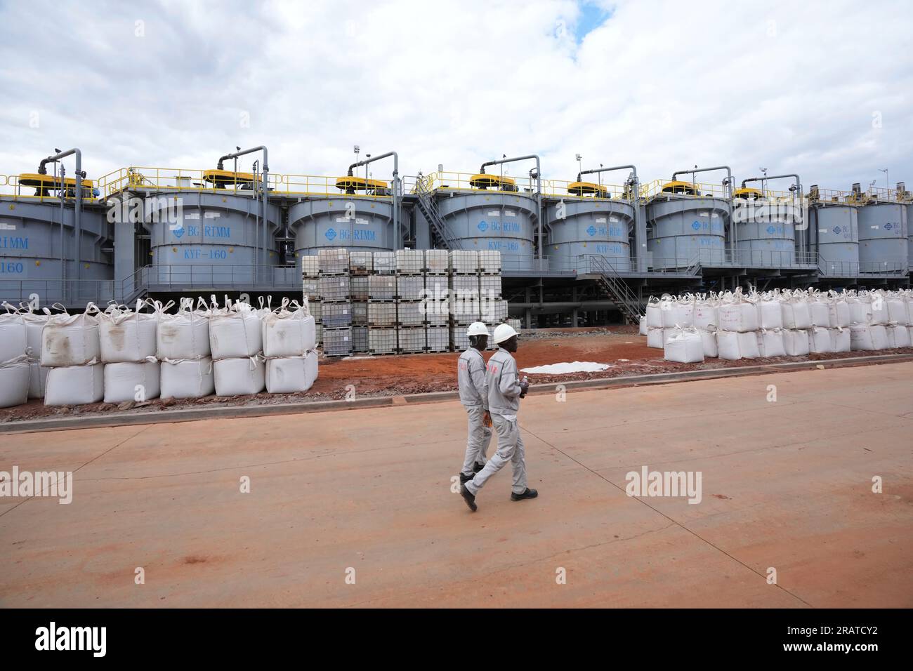 Workers walk past lithium filled bags on the grounds of Prospect ...