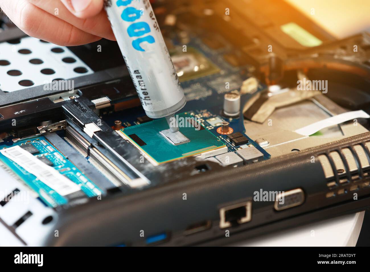 Hand a repairman uses thermal paste syringe apply thermal compound to a ...