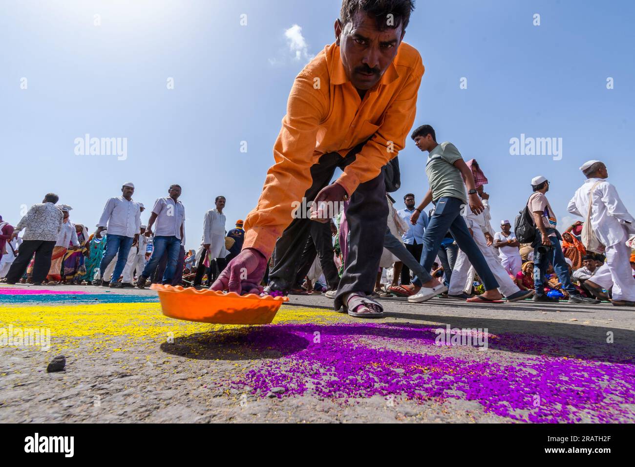 A low angle shot of a man drawing rangoli for welcoming palkhi Stock ...