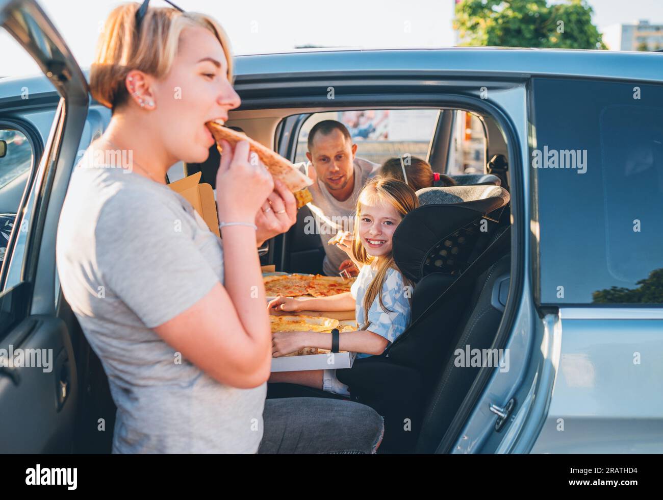 Positive smiling girl in child car seat while family car trip brake ...
