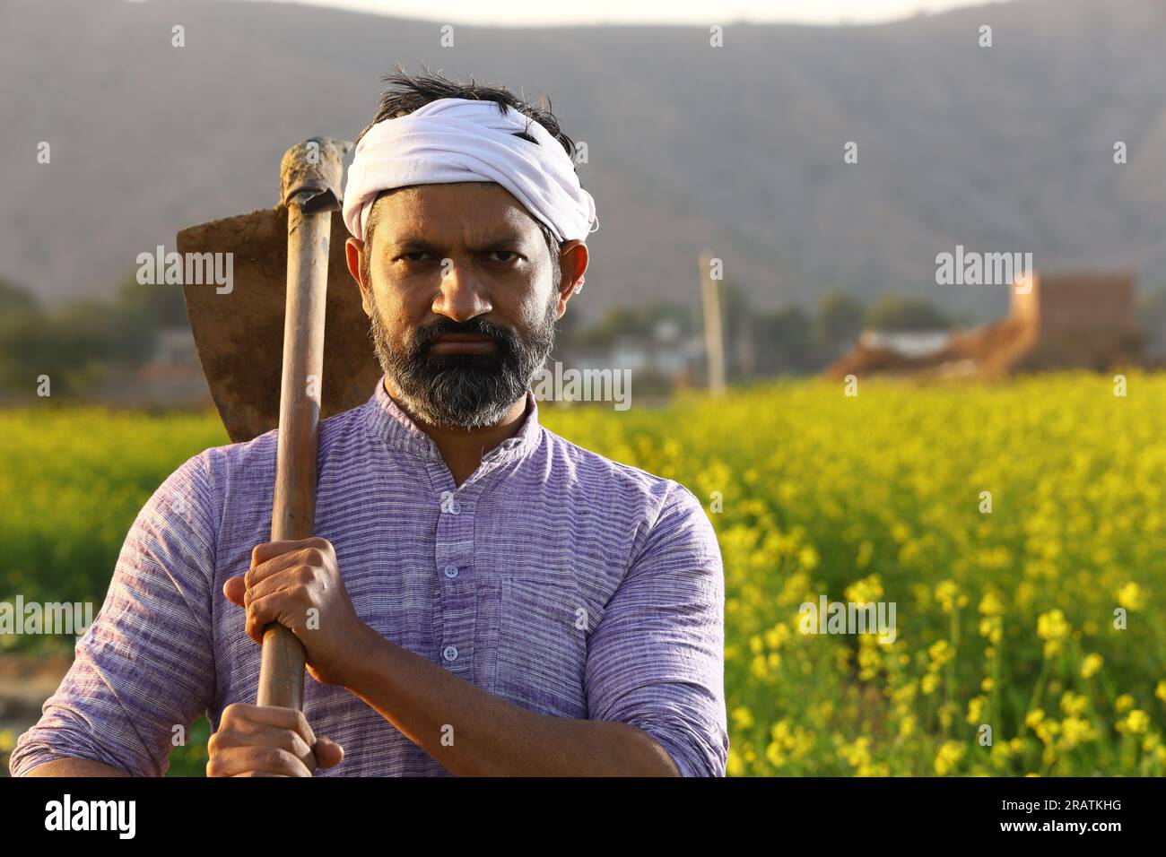 Angry bearded Indian farmer in turban standing with a shovel in his ...