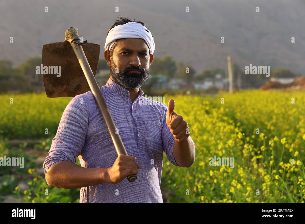 Angry bearded Indian farmer in turban standing with a shovel in his ...