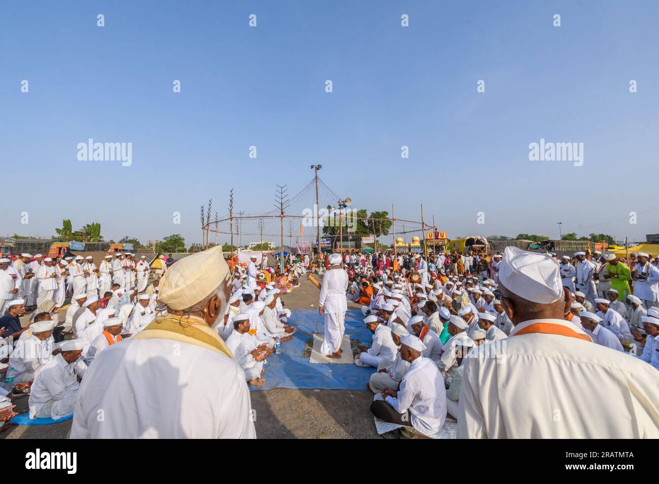 Wide shot of warkari conducting kirtan at an open ground in Lonand ...