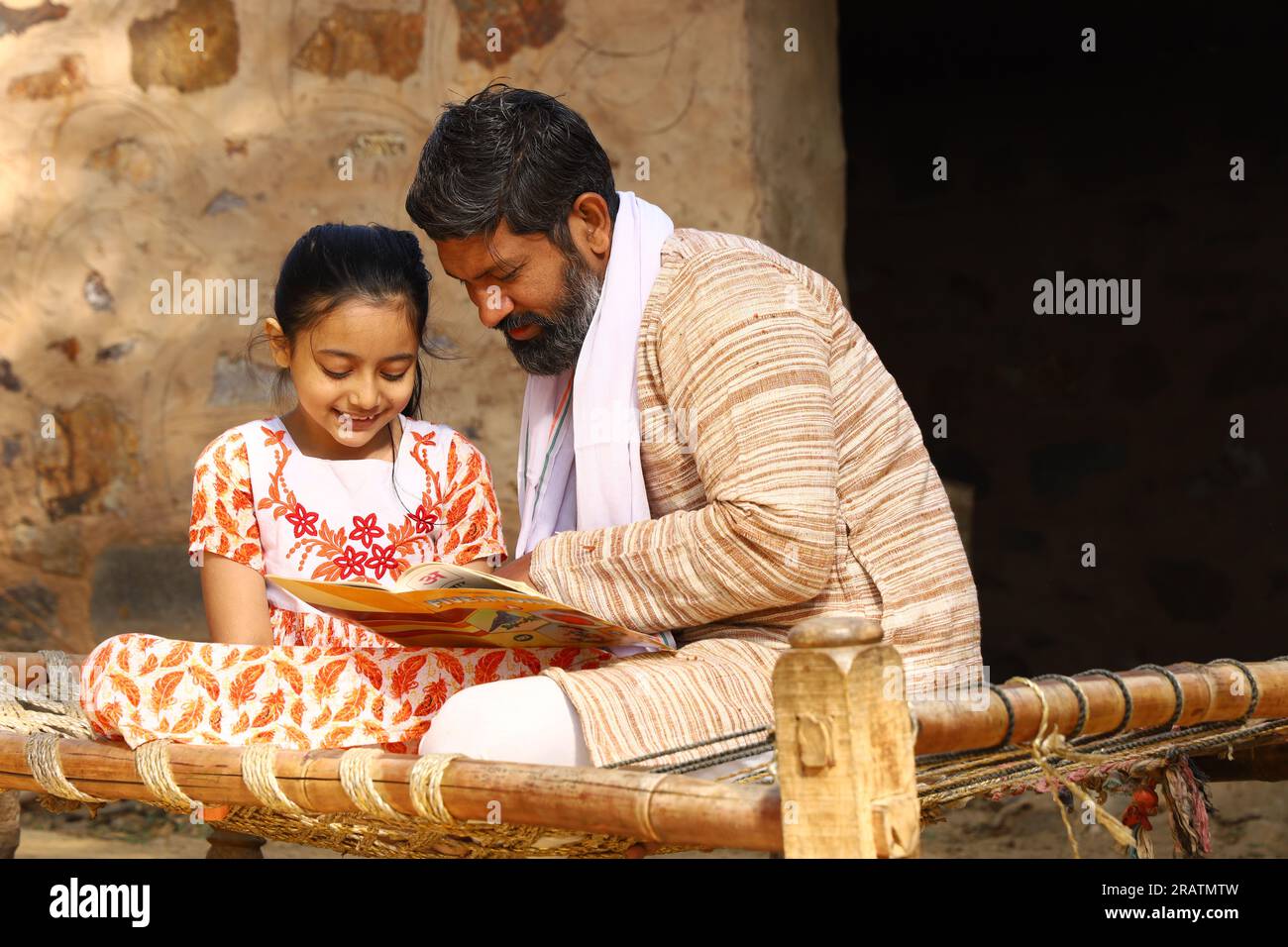 Rural Indian father and daughter studying book together. Child ...