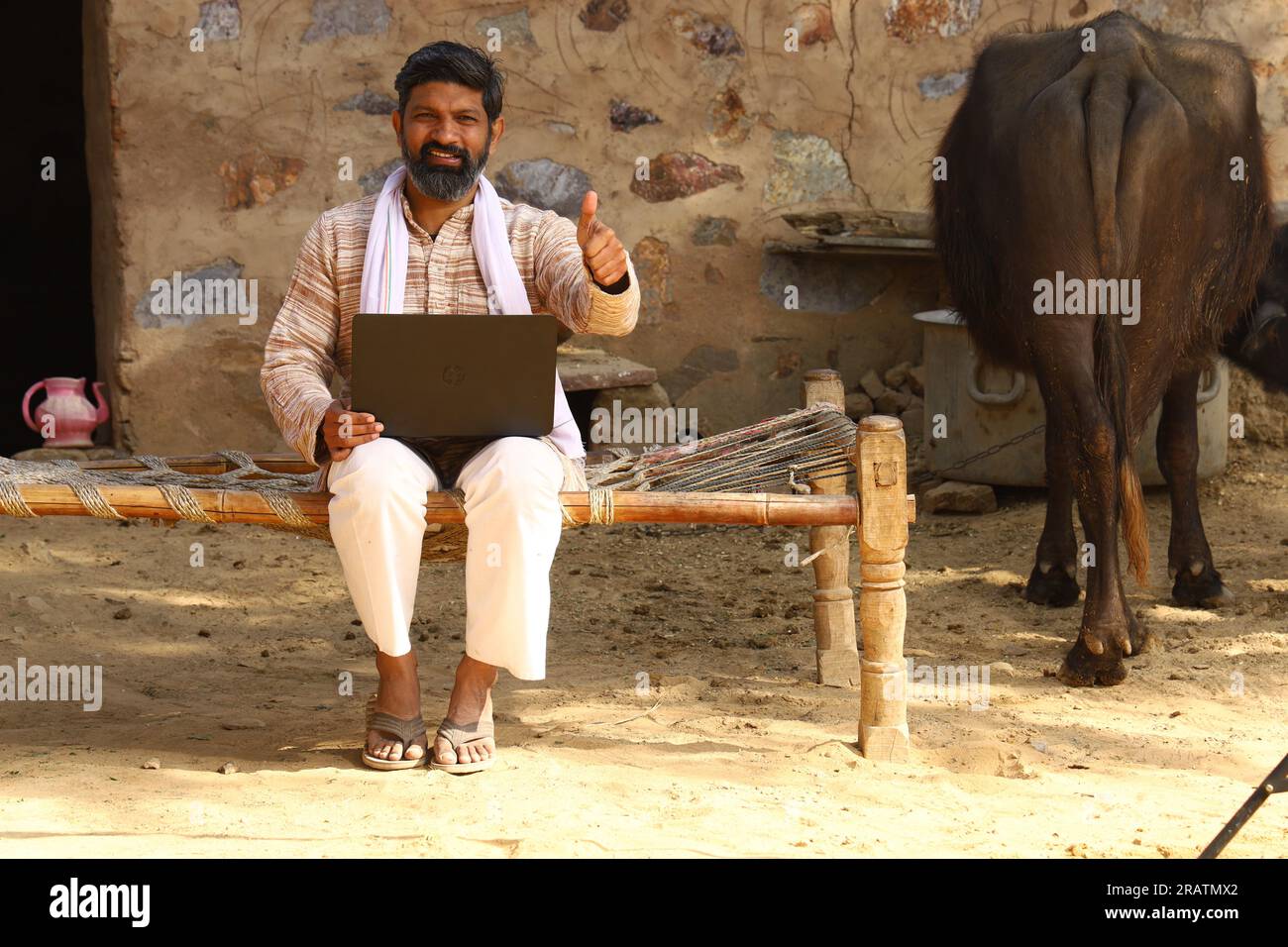 Happy rural Indian villager sitting with laptop in kurta pajama in a ...