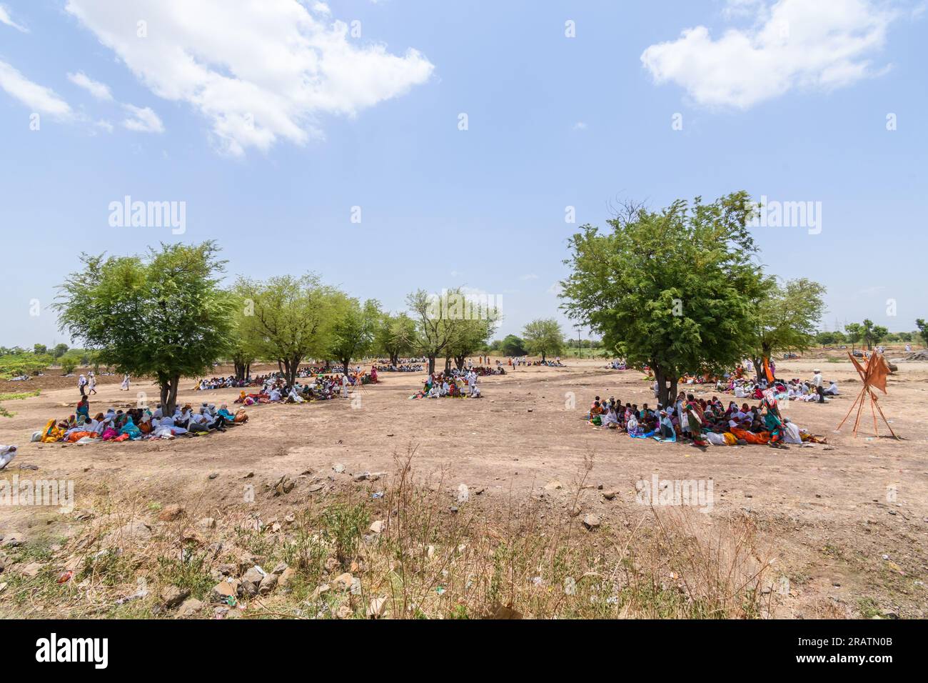 Warkari from palkhi sitting under trees for shade during afternoon ...