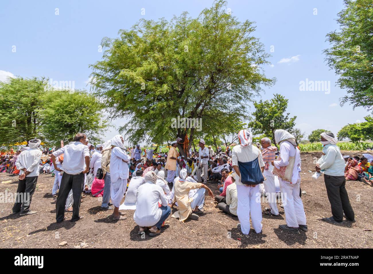 A group of people sitting under a tree to enjoy bharud Stock Photo - Alamy