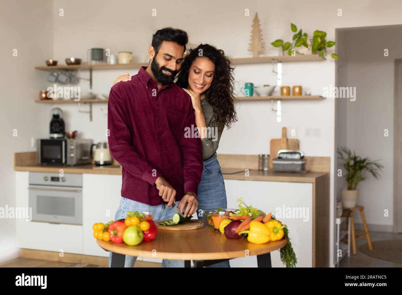 Cooking at home concept. Happy middle eastern woman hugging her husband ...