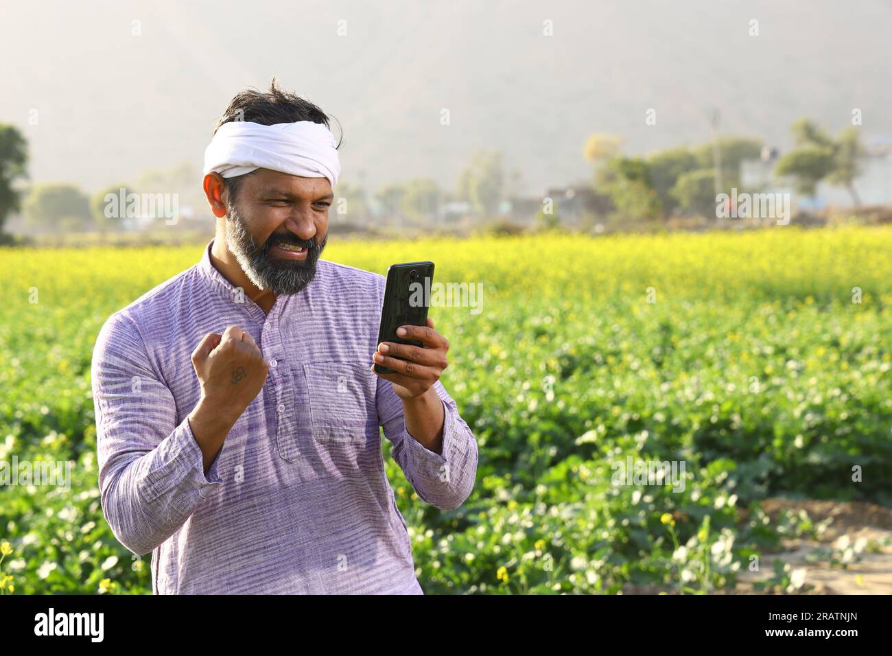 Happy Indian farmer feeling the wind while standing in the field ...