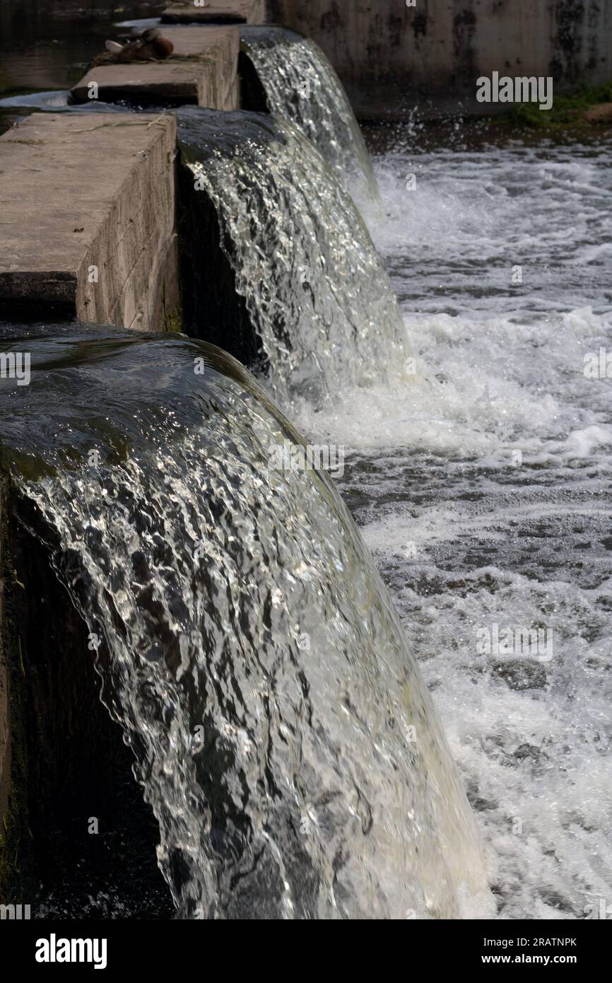 photo of water moving downstream through holes in the stone structure ...