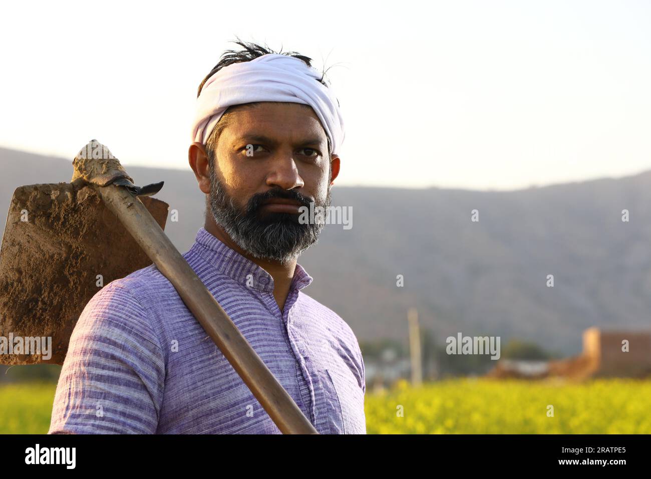 Angry bearded Indian farmer in turban standing with a shovel in his ... Angry bearded Indian farmer in turban standing with a shovel in his ...