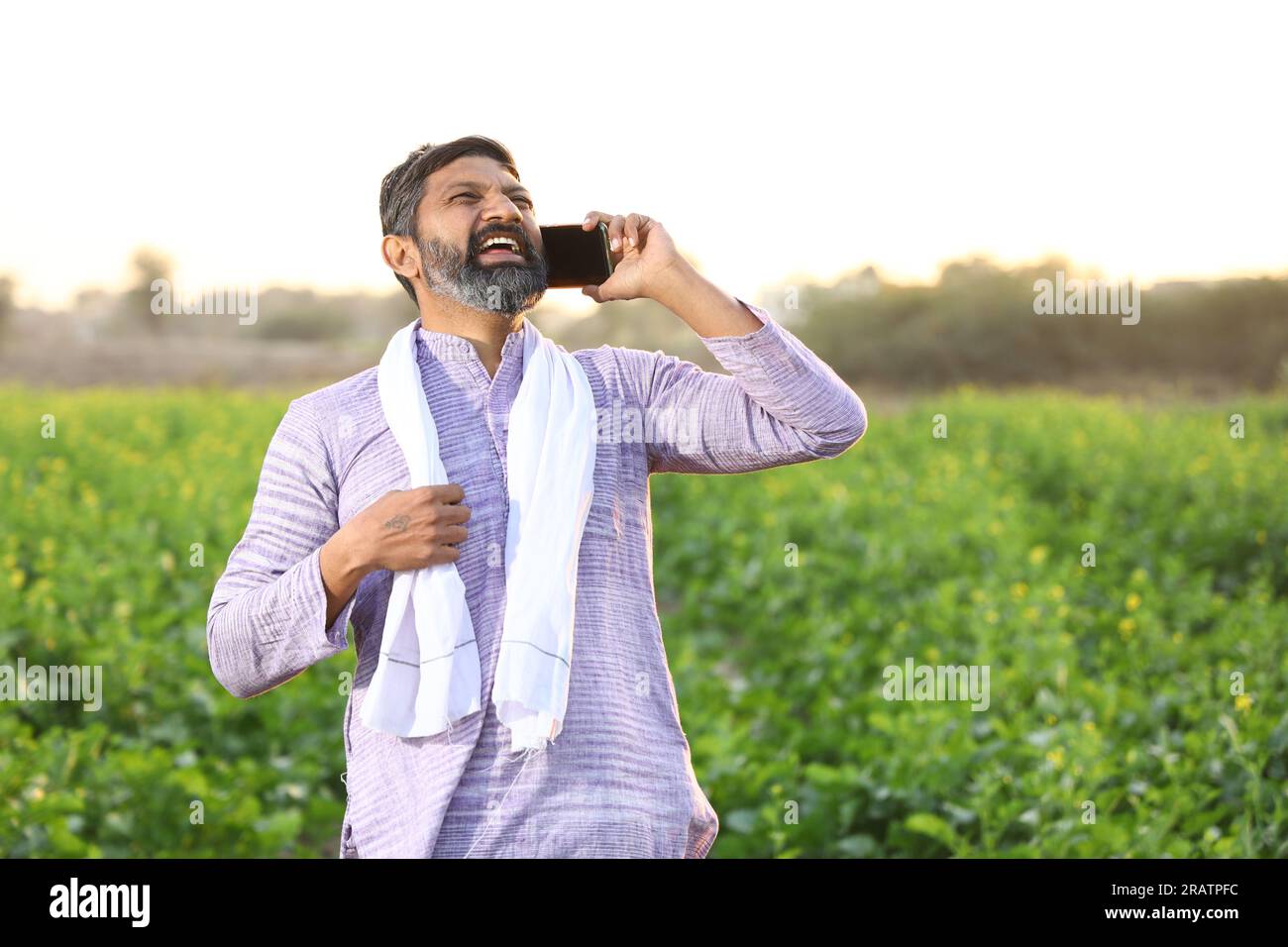 Happy Indian farmer feeling the wind while standing in the field ...